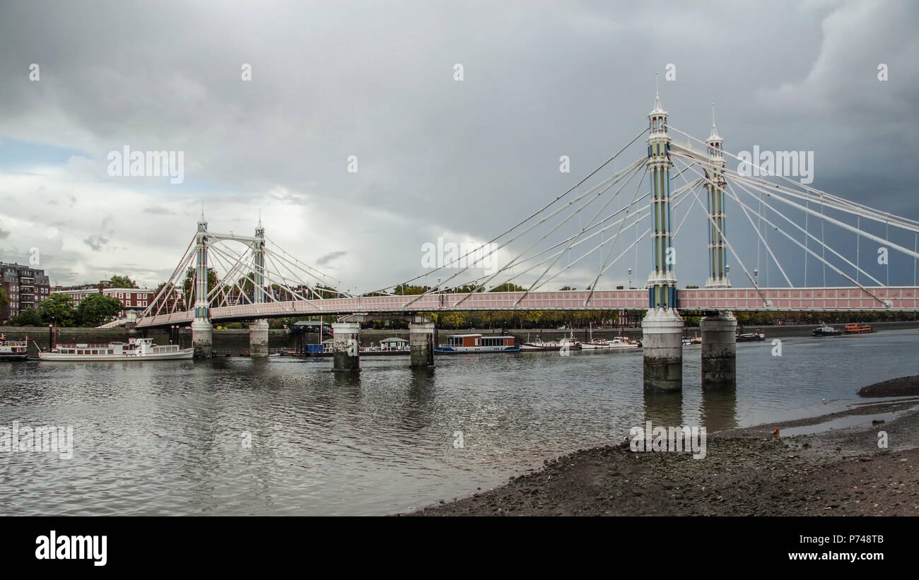 Albert Bridge over river Thames in London on gray overcast day. It ...