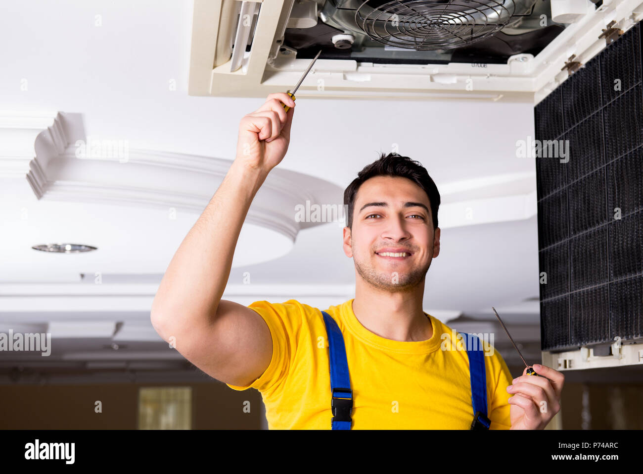 Repairman repairing ceiling air conditioning unit Stock Photo - Alamy