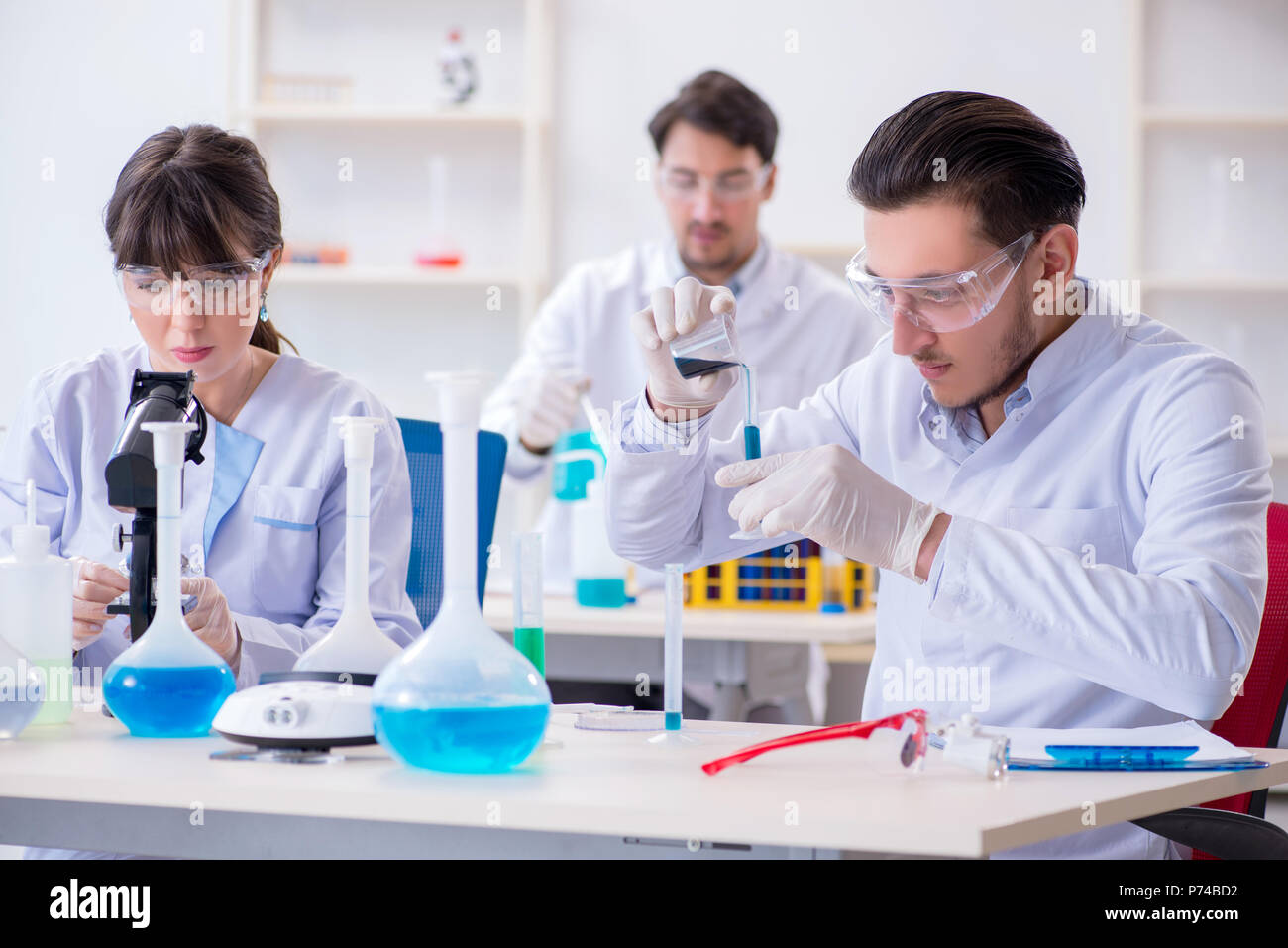 Team of chemists working in the lab Stock Photo - Alamy