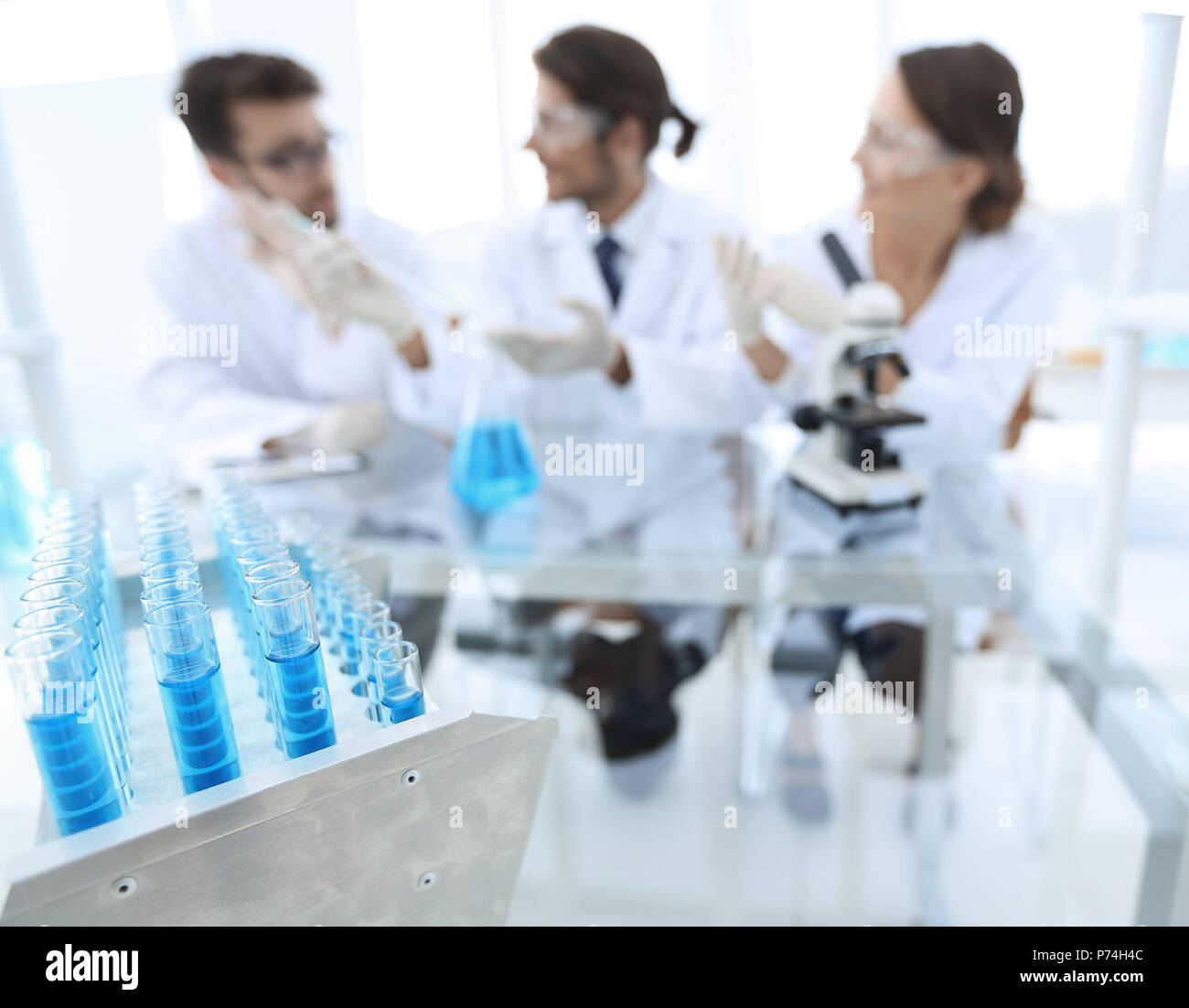 background image of scientists studying blue liquid in a flask Stock ...