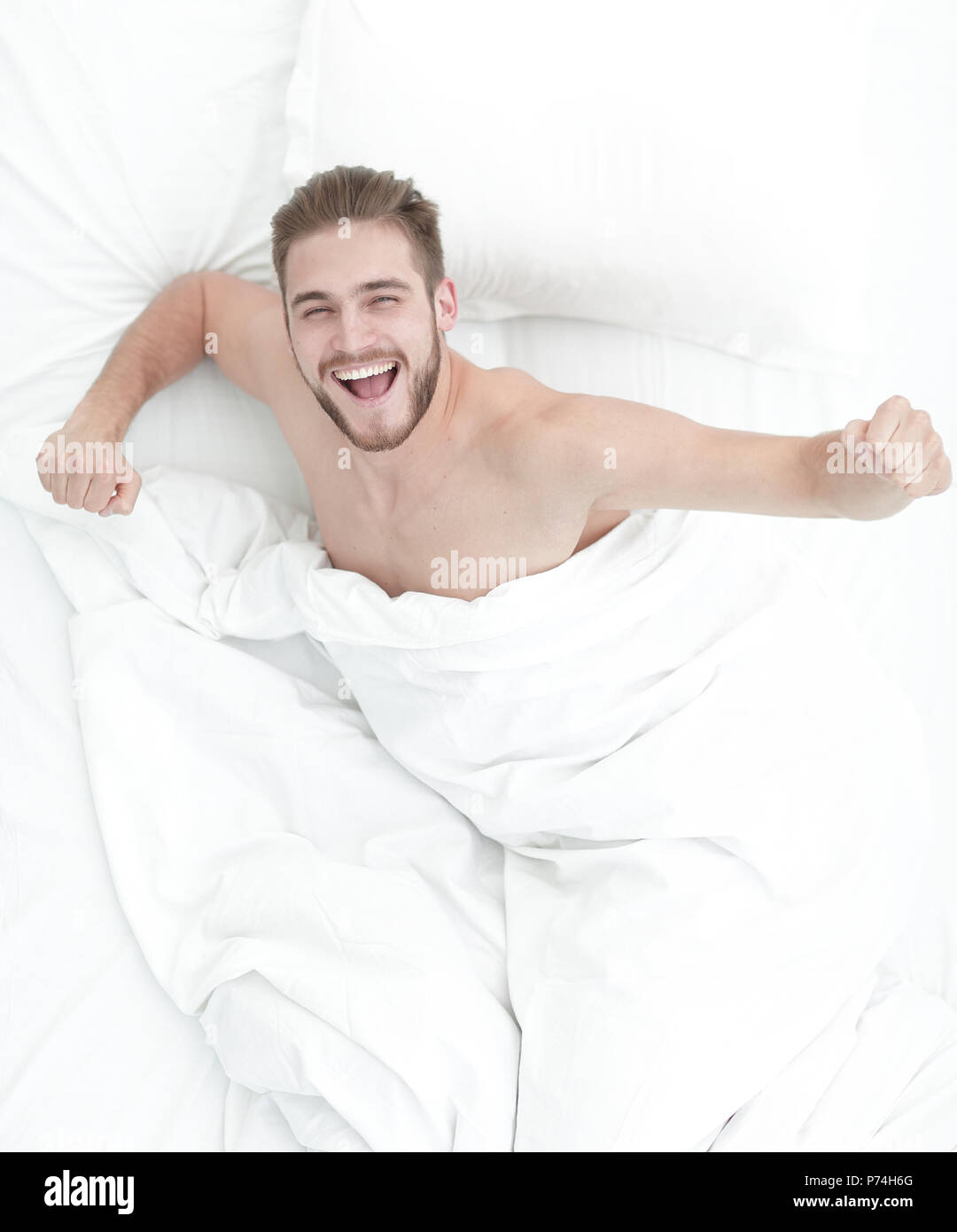 top view. happy man waking up in a comfortable bed Stock Photo - Alamy