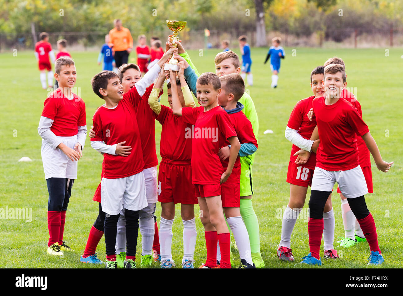 Kids soccer football - young children players celebrating with a trophy ...