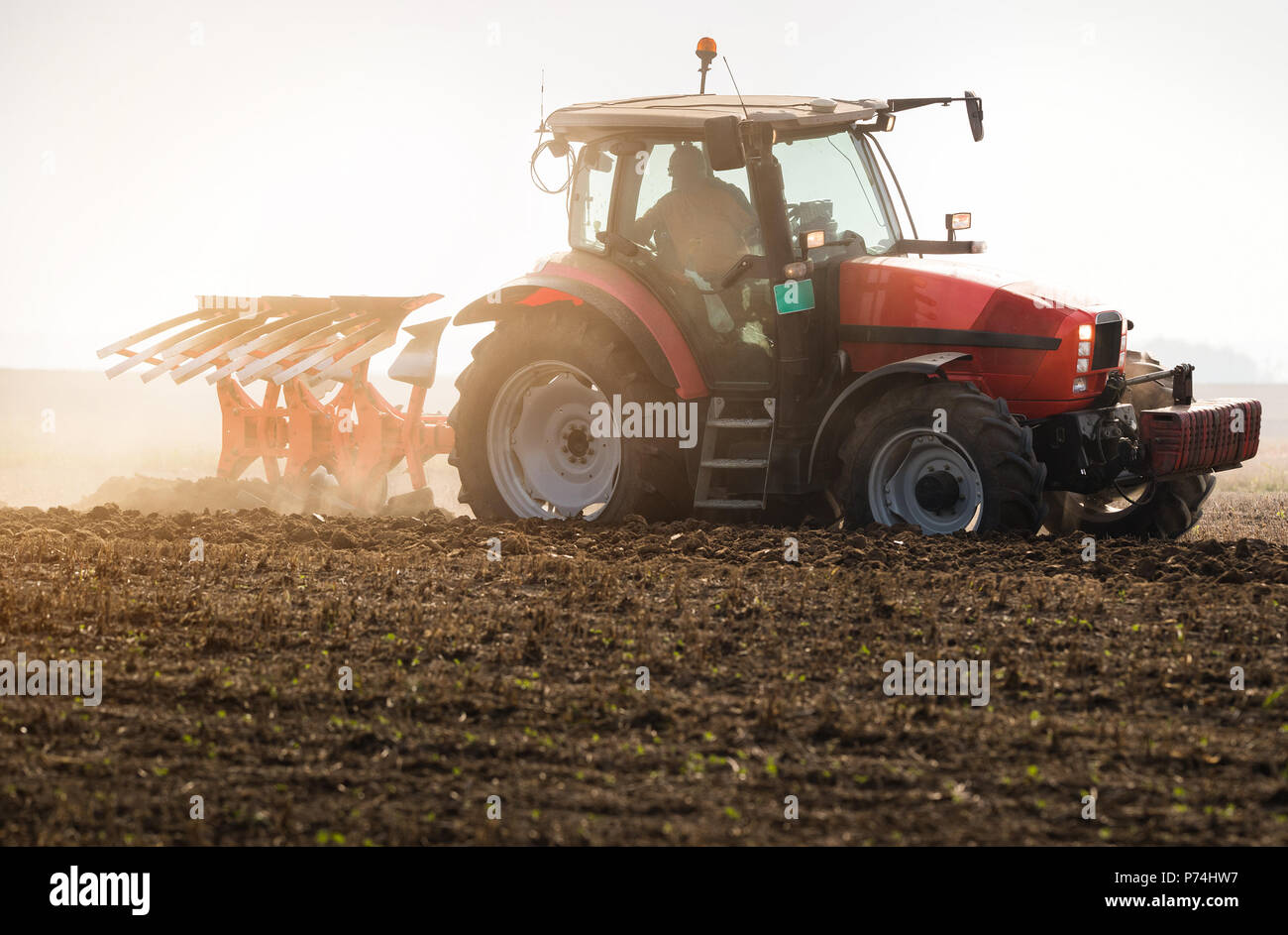 Tractor plowing fields -preparing land for sowing Stock Photo - Alamy