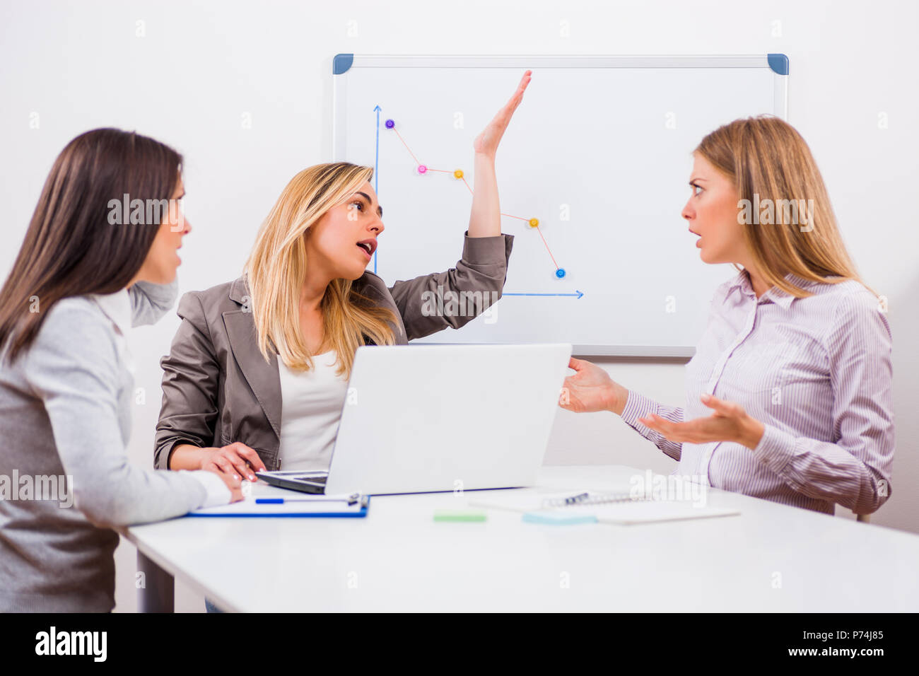 Three businesswomen are arguing at meeting in their office Stock Photo ...