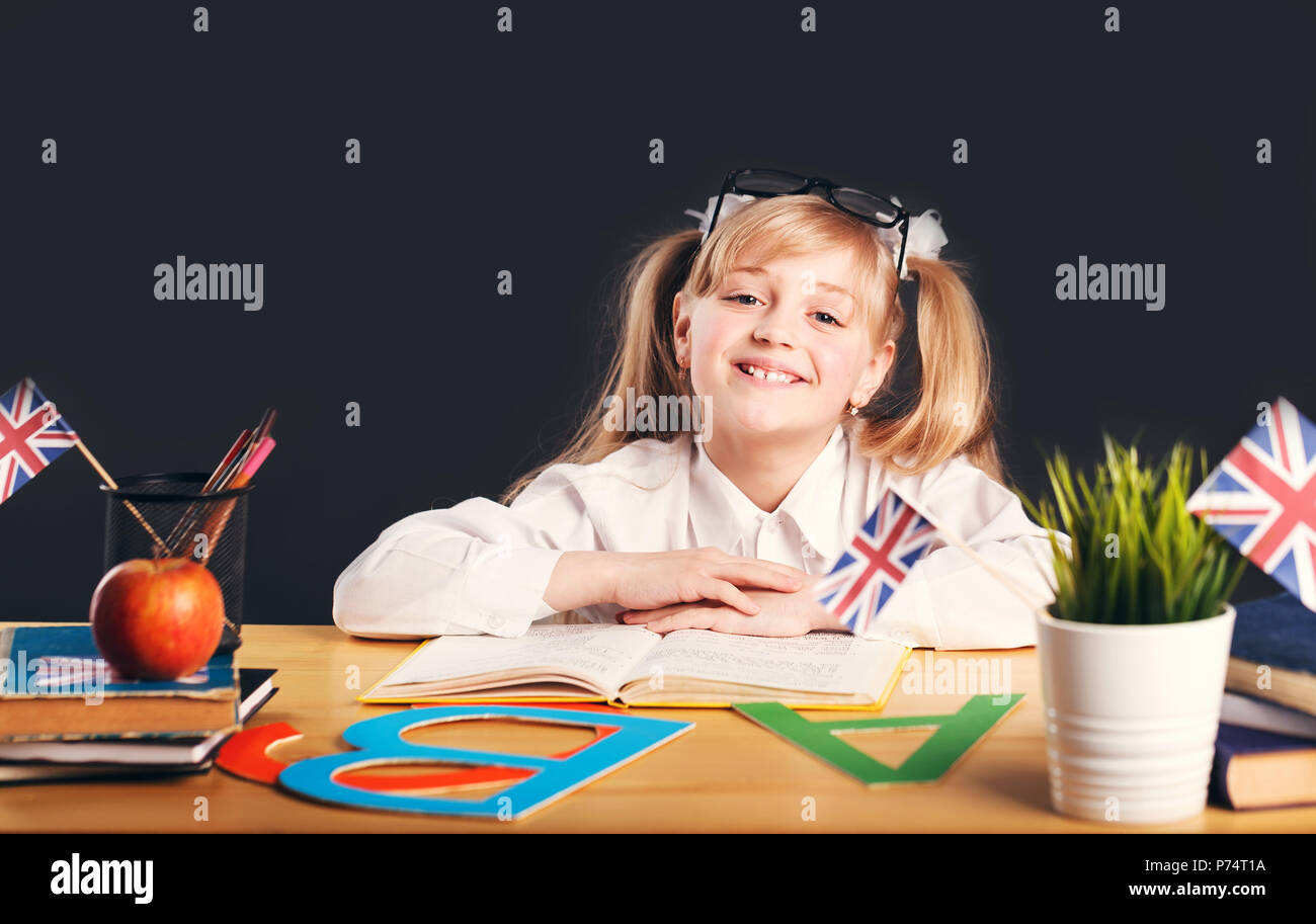 Happy smiling girl learning English language with book before dark ...