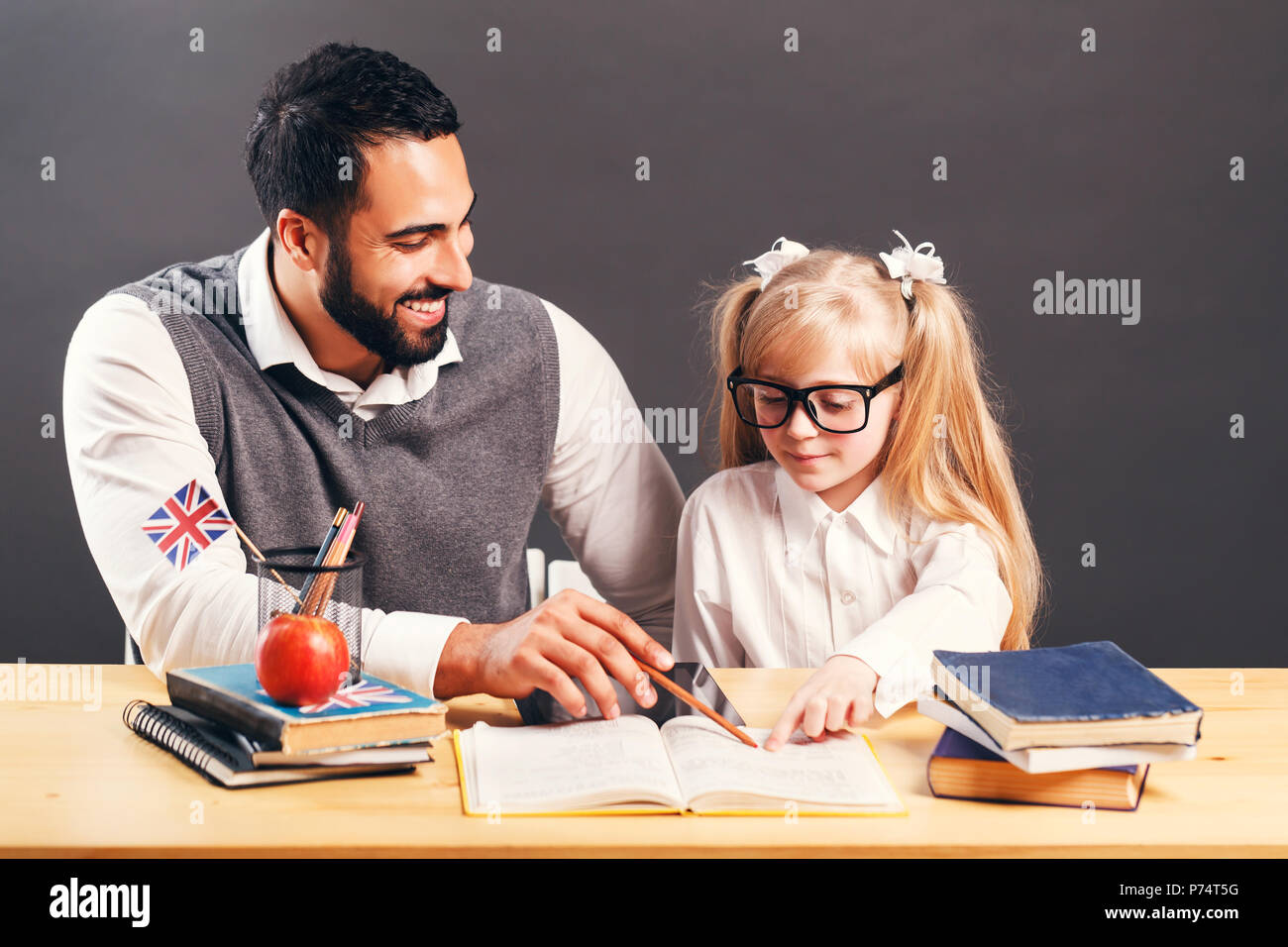 Intelligent male teacher explaining new material to the primary student ...