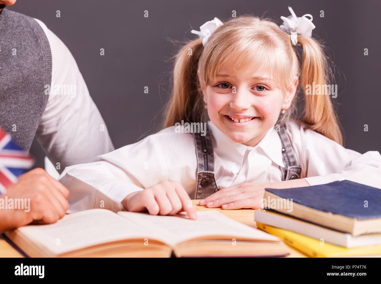 Successful kid student girl smile while reading English book with ...