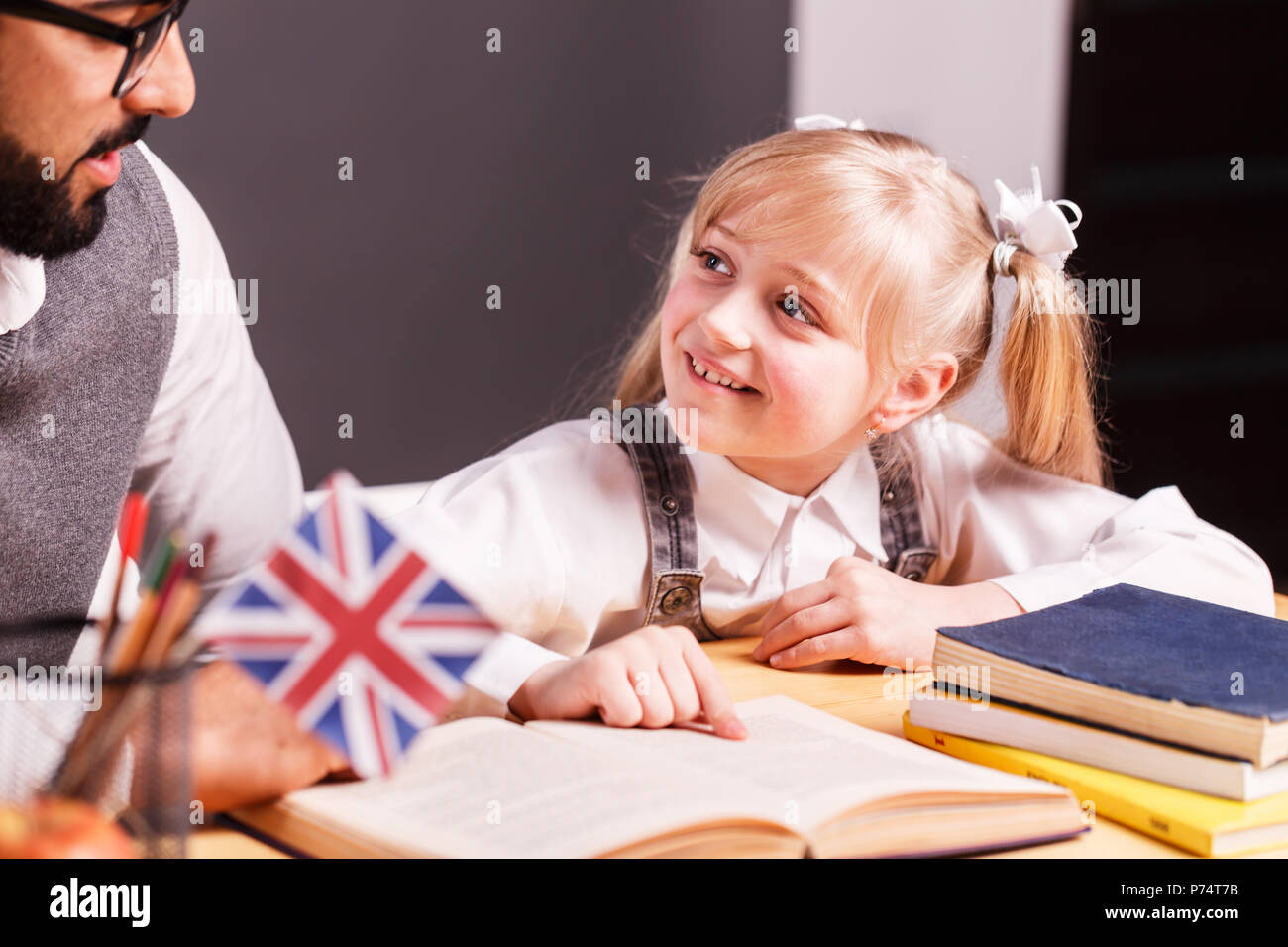 Successful kid student girl smile while reading English book with ...