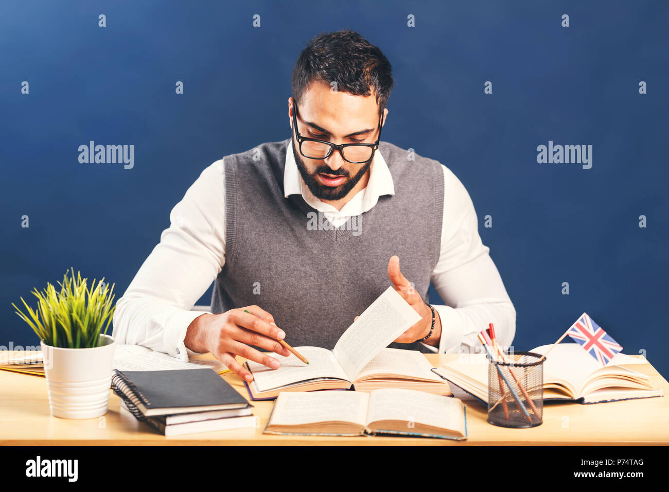 Eastern bearded man working hard learning english, wearing gray sweater ...