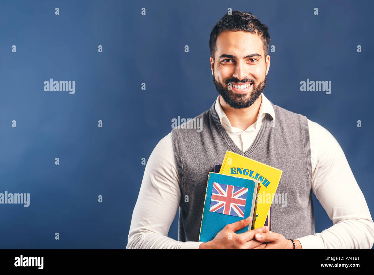 Eastern bearded man holding English book, successful language learning ...