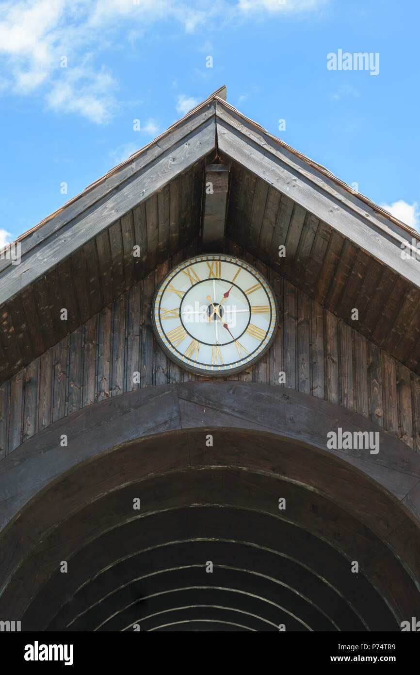 wood roof arcade with old roman golden numbers clock showing 13:25 ...