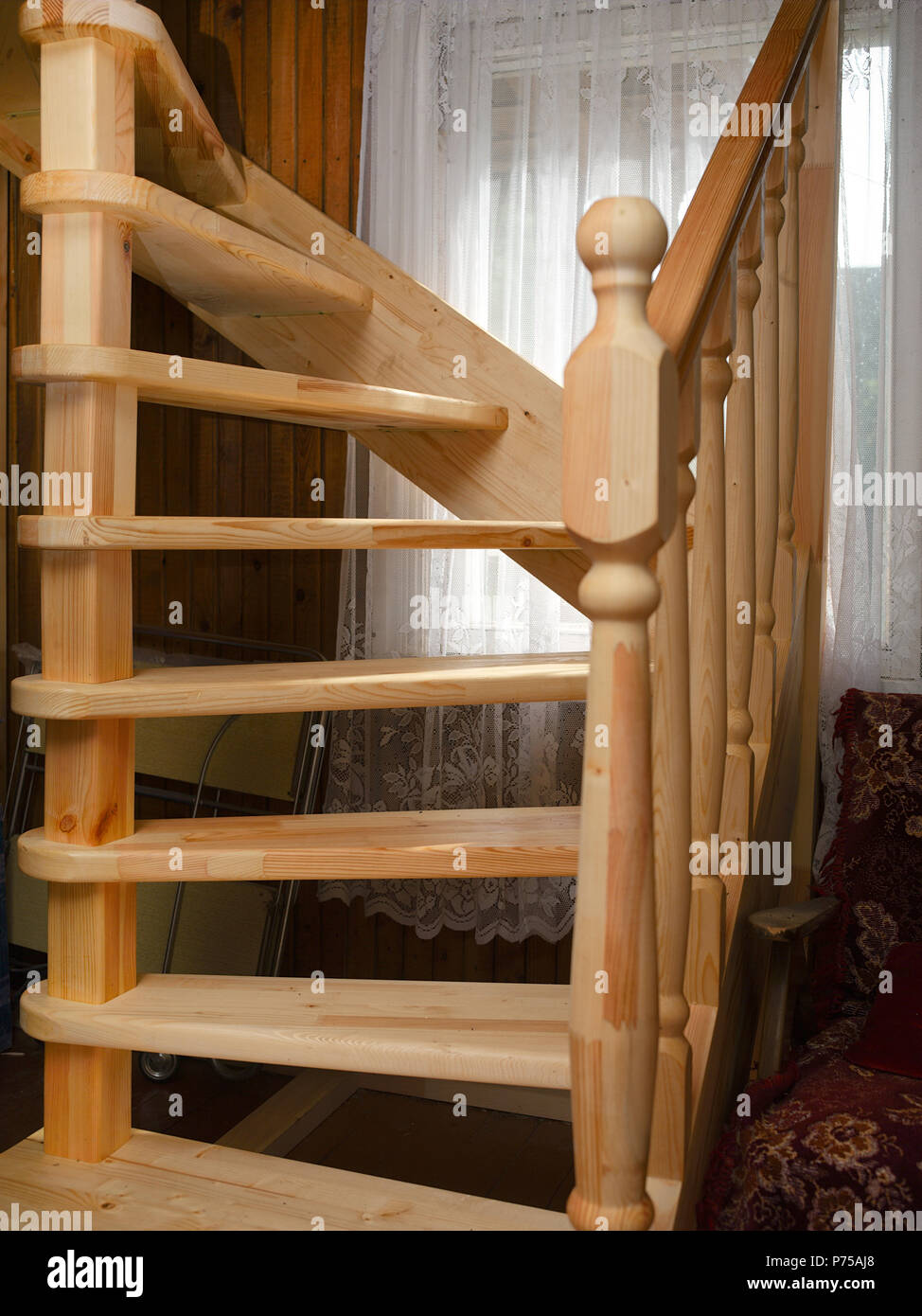 Traditional wooden staircase next to the window, vertical composition ...