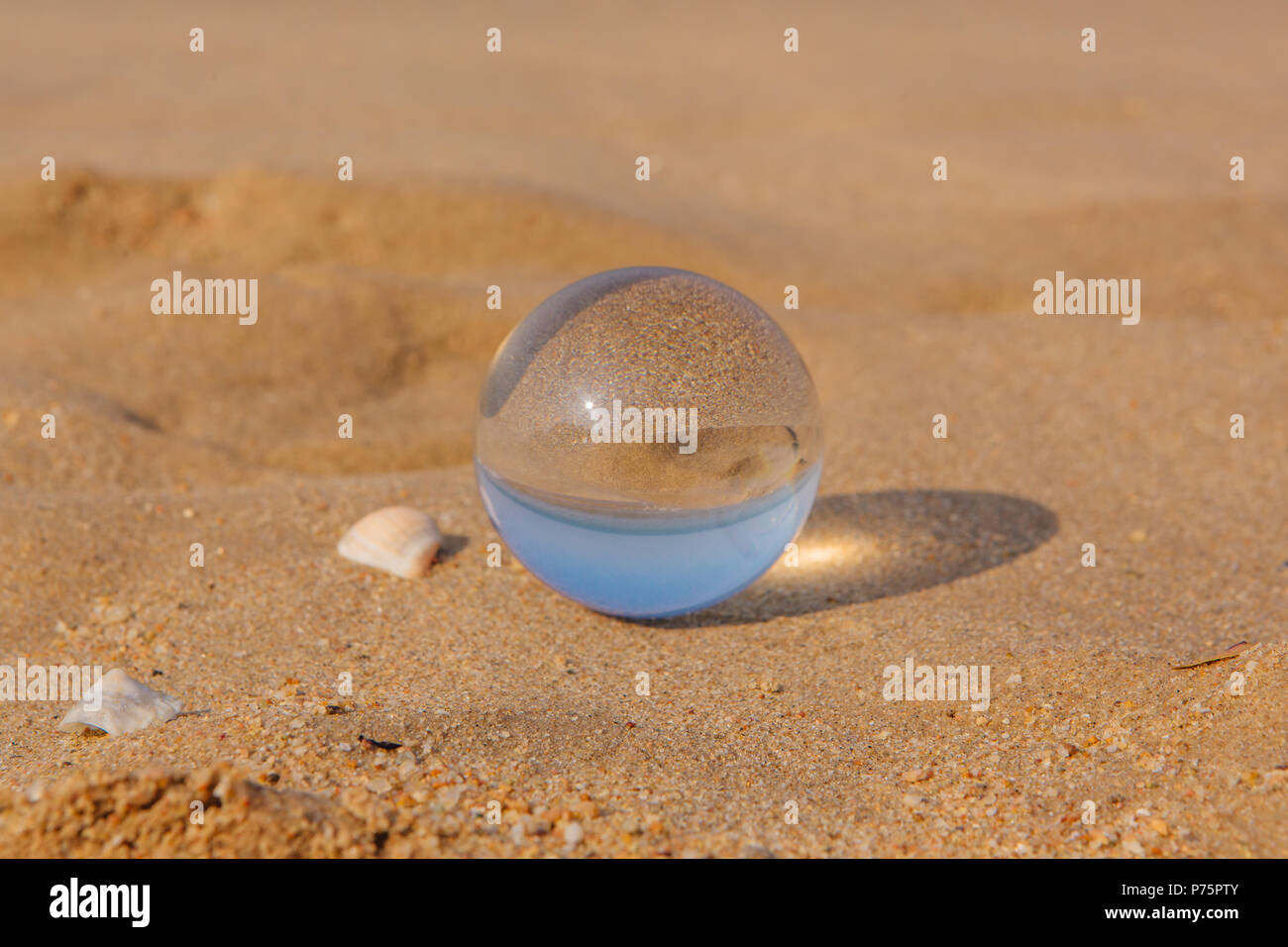 Lens ball on the sand texture of the beach Stock Photo - Alamy