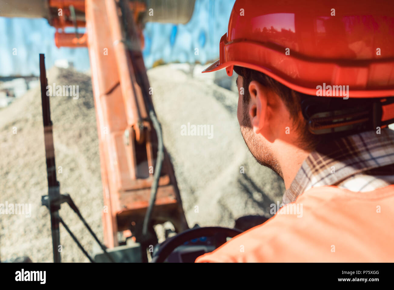 Worker on construction site operating wheel loader Stock Photo - Alamy