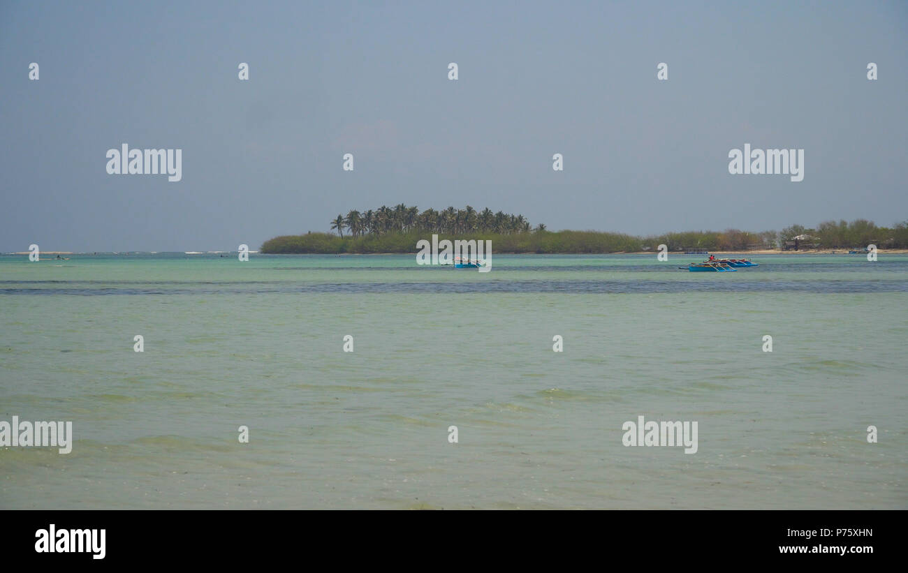 Tropical island with white sandy beach, palm trees in blue lagoon ...