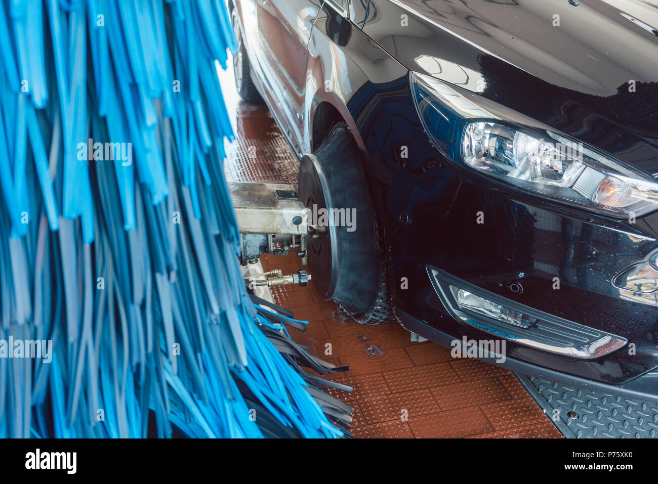 Vehicle in the car wash rims being washed Stock Photo - Alamy