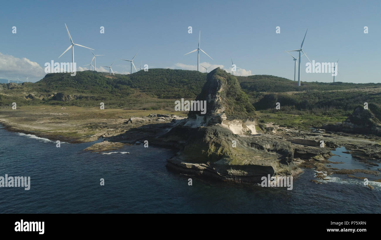 Natural rock formation of limestone stone on the coast with windmills ...