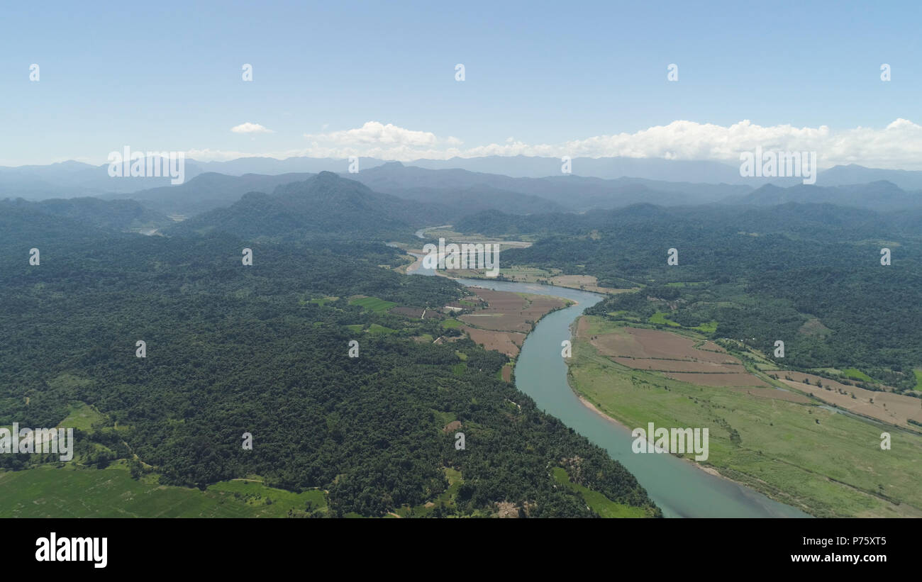 River in mountain valley flowing through farmlands. Aerial view of ...