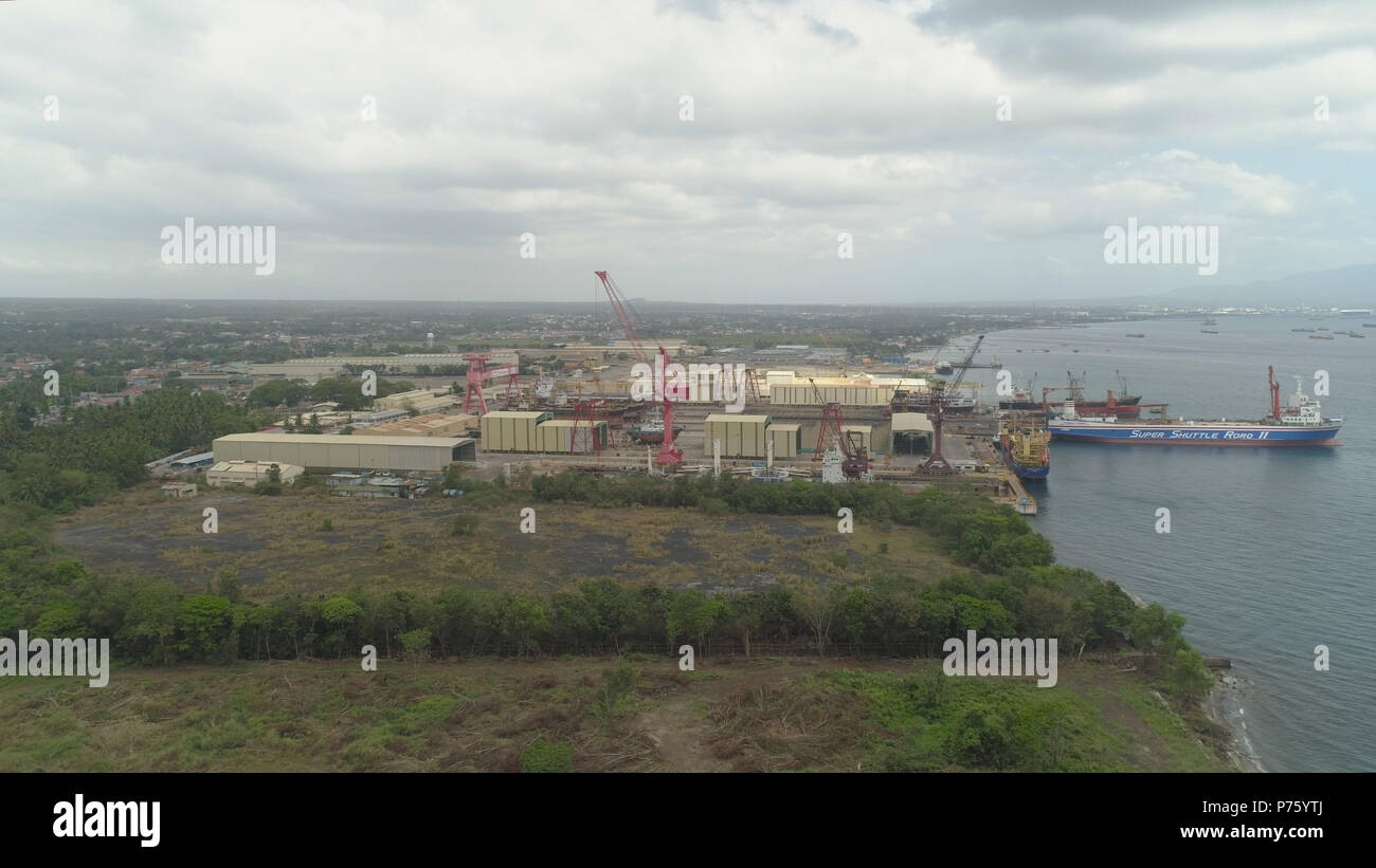 Aerial view of shipyard with ships in docks, cranes and warehouses ...