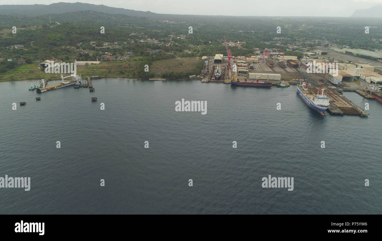Aerial view of shipyard with ships in docks, cranes and warehouses ...