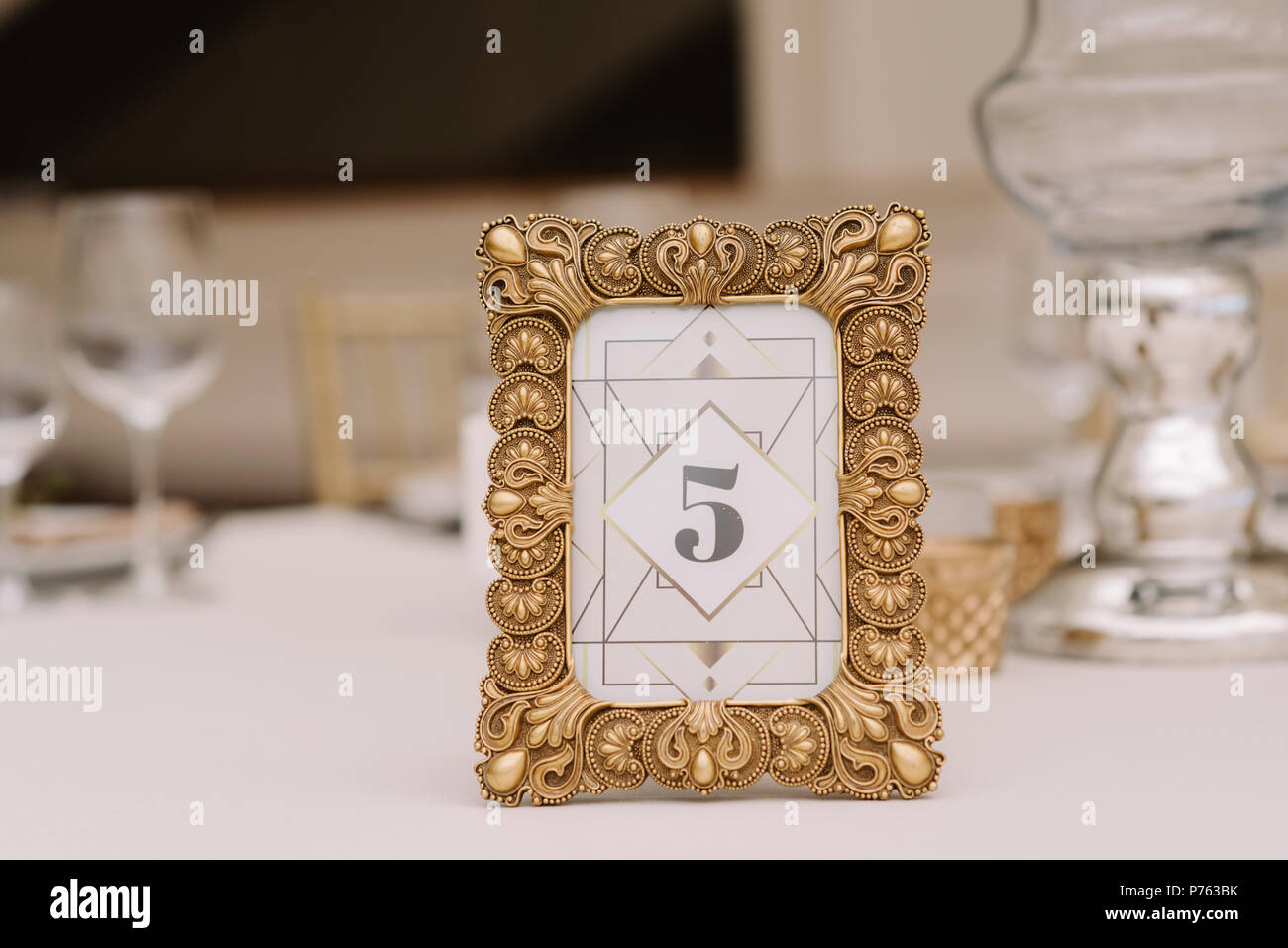 Wedding decor with table number in golden frame. Number Five Stock ...