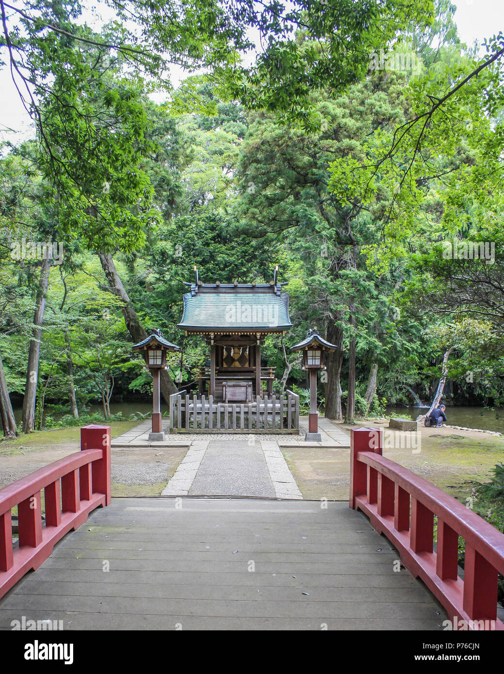 Red footbridge leading to small Shinto shrine inside large shrine ...