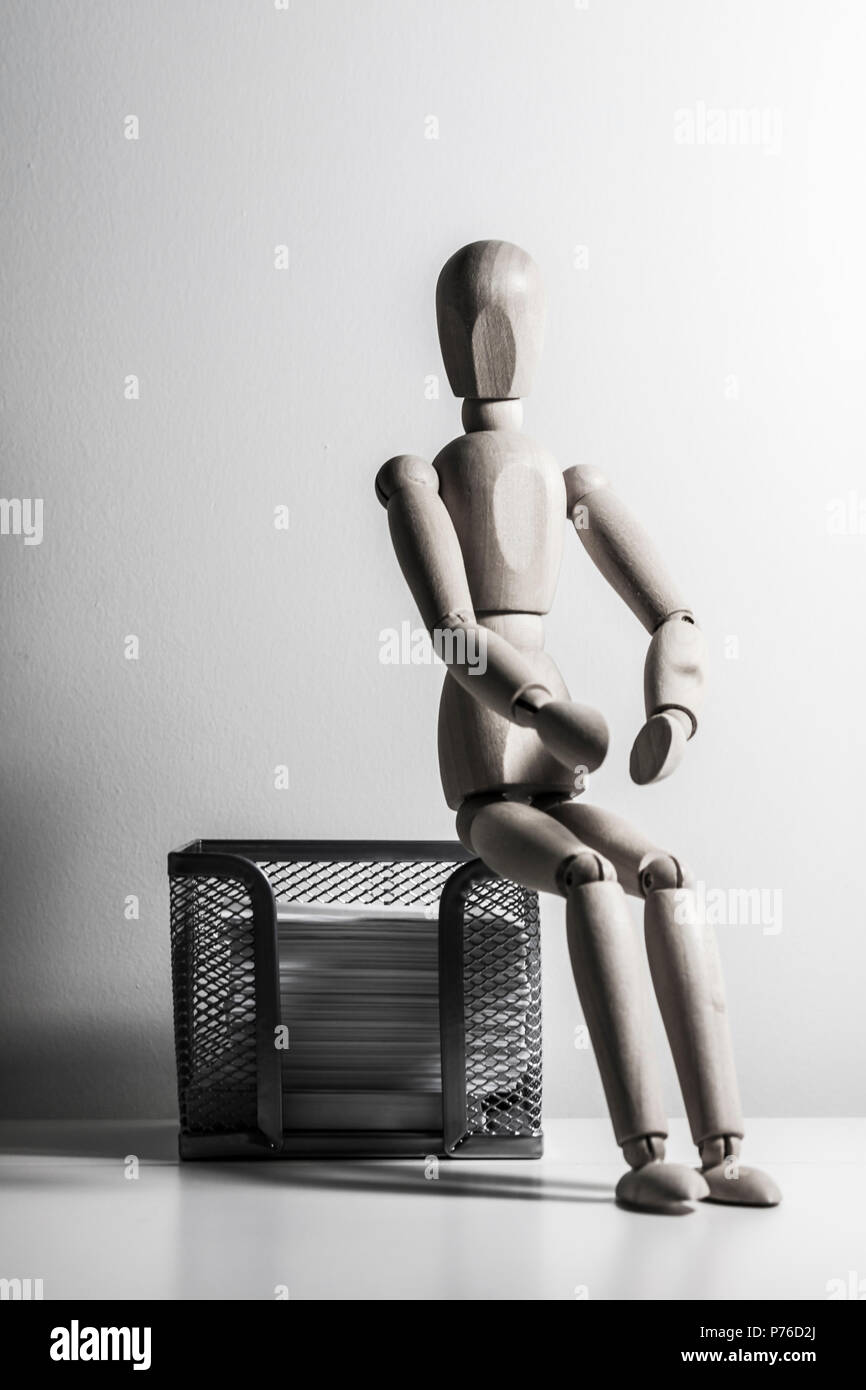 Wooden puppet sitting on a metal box for note sheets Stock Photo - Alamy