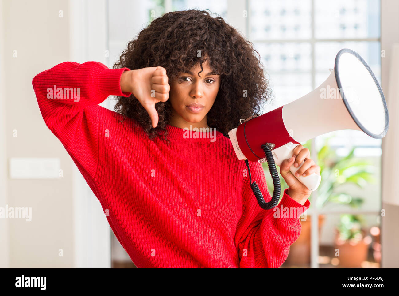 African american woman holding megaphone speaker with angry face ...