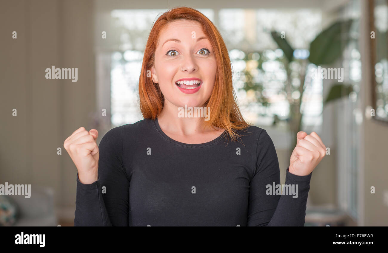 Redhead woman at home screaming proud and celebrating victory and ...