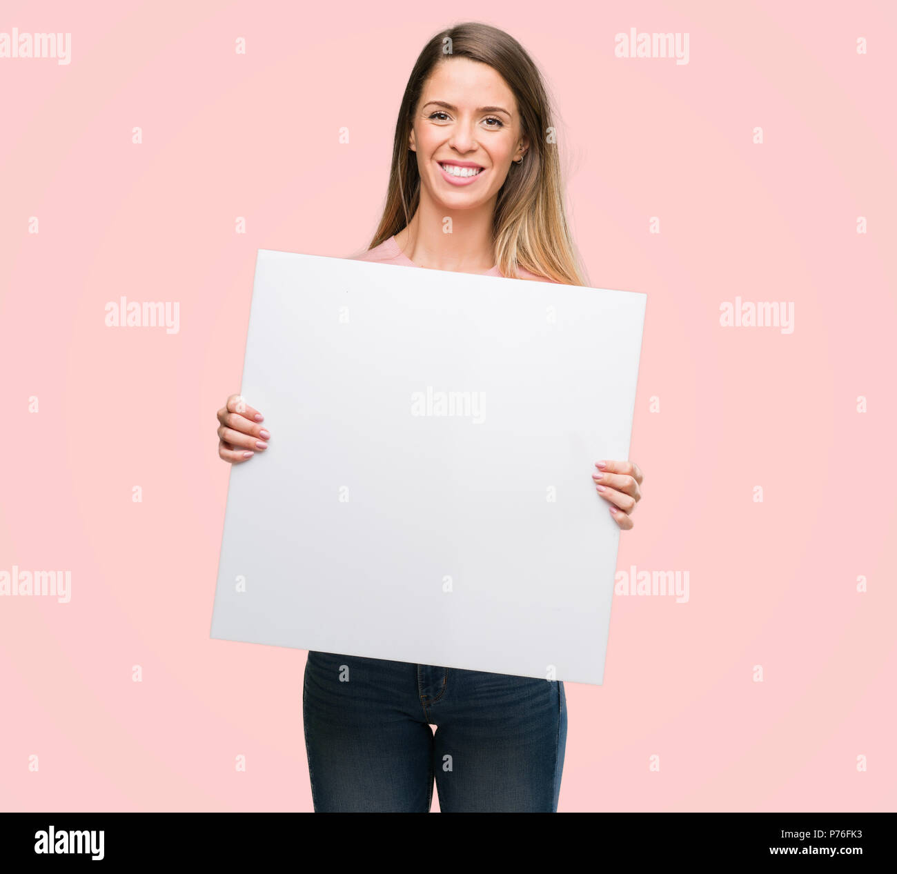 Beautiful young woman holding advertising banner with a happy face ...