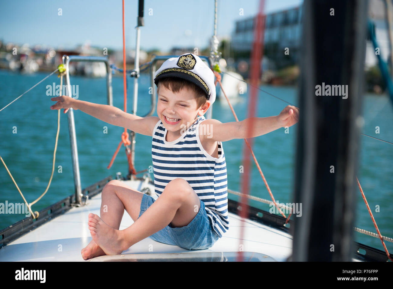 happy delightful kid in captain cap sitting on luxury yacht board Stock ...