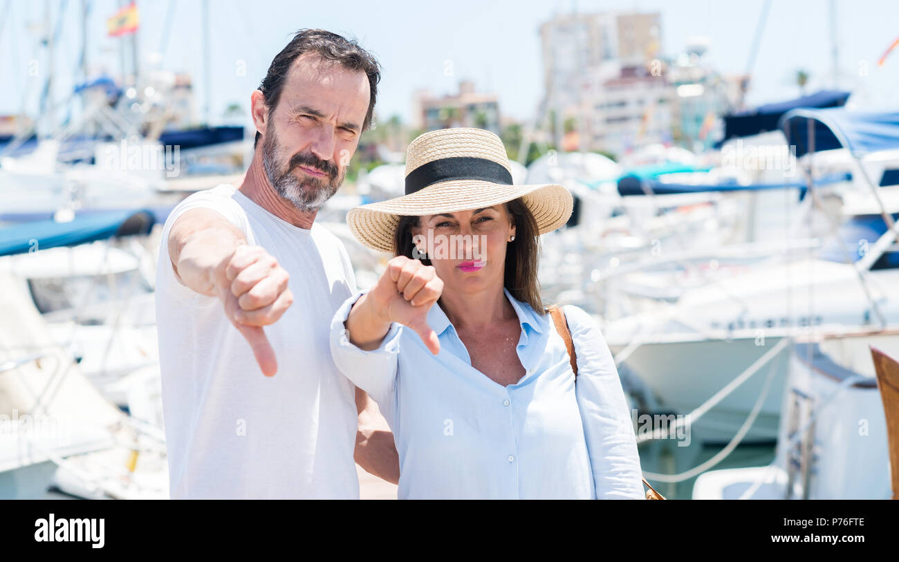 Middle age couple in marina with angry face, negative sign showing ...