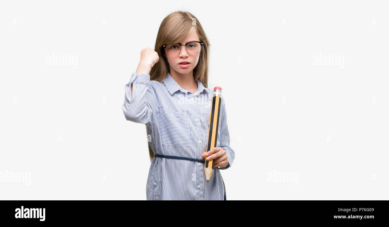 Young blonde child holding big pencil annoyed and frustrated shouting ...