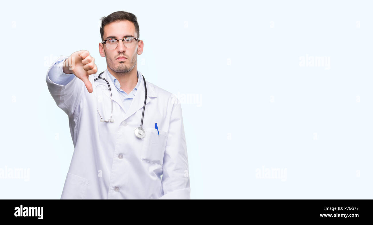 Handsome young doctor man looking unhappy and angry showing rejection ...