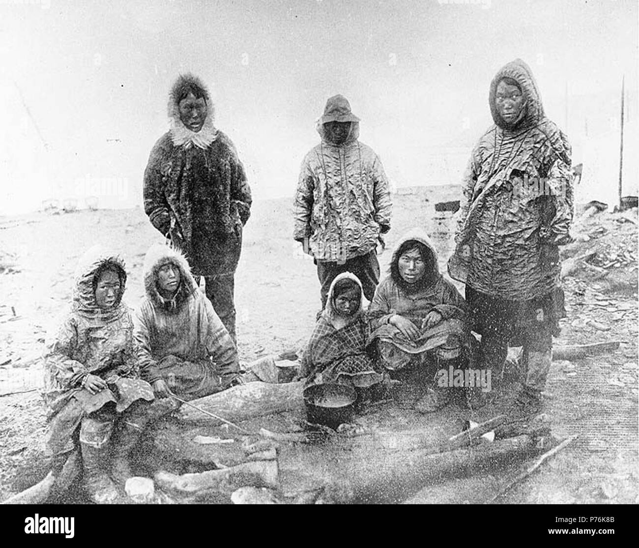 . English: Eskimos wearing gut parkas gathered around campfire, Penny ...