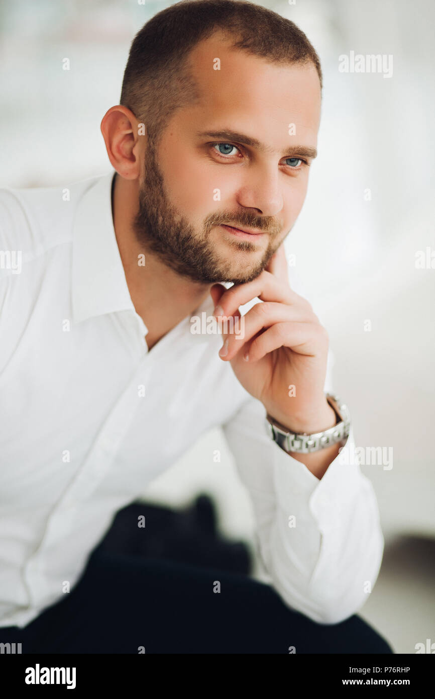 Confident man holding chin by hand and looking at camera Stock Photo ...