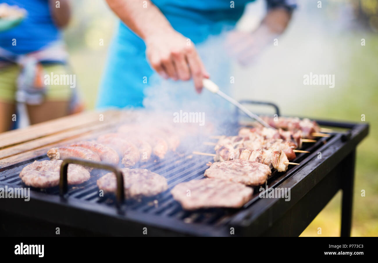 Happy students having barbecue on summer day Stock Photo - Alamy