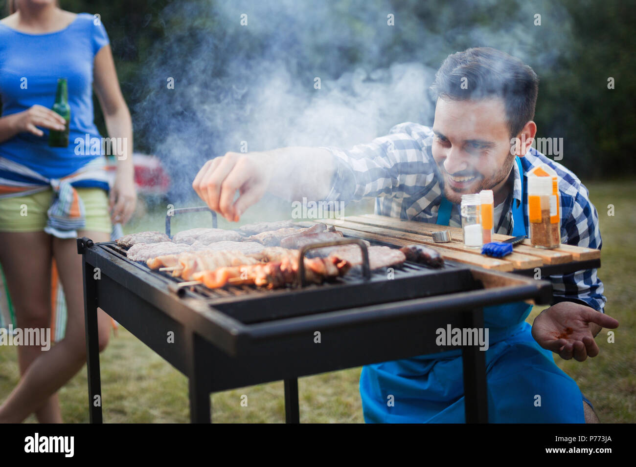 Happy students having barbecue on summer day Stock Photo - Alamy