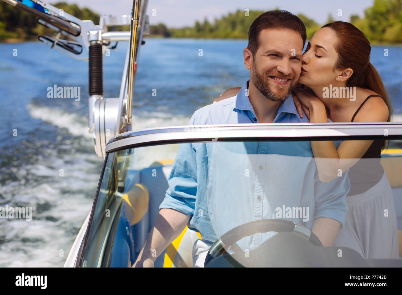 Tender woman kissing husband while he sailing a boat Stock Photo - Alamy