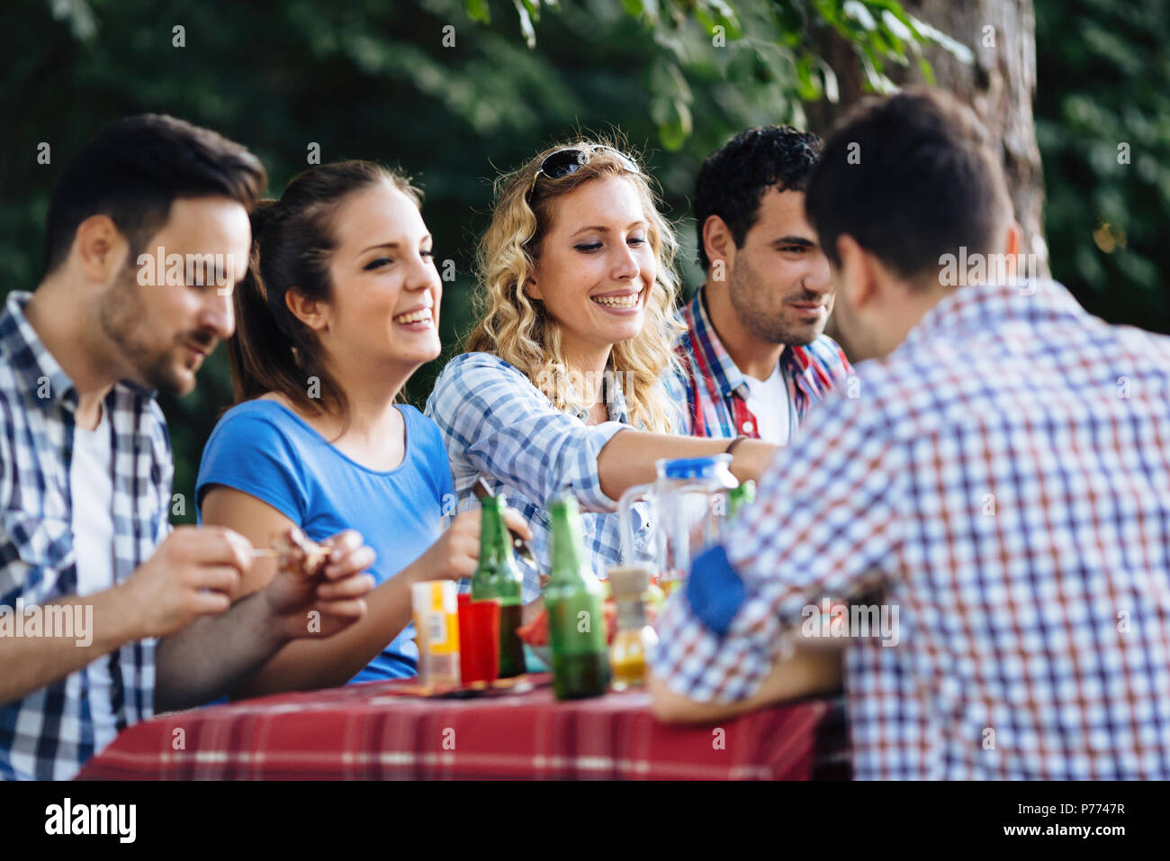 Group of happy people eating food outdoors Stock Photo - Alamy