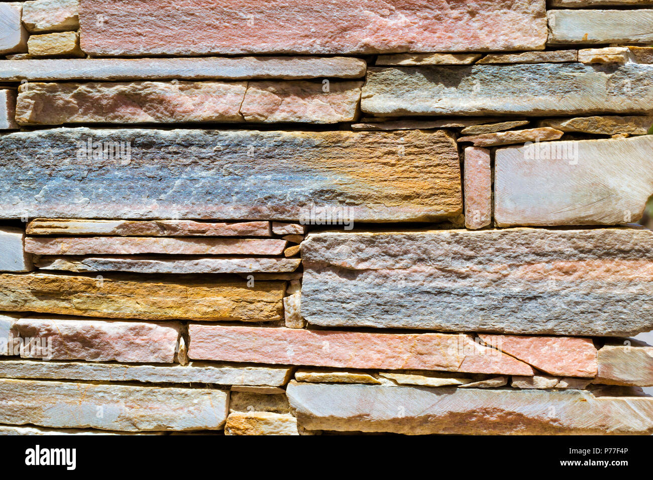 Decorative stone wall, pieces of rock bonded with cement. Cobble ...