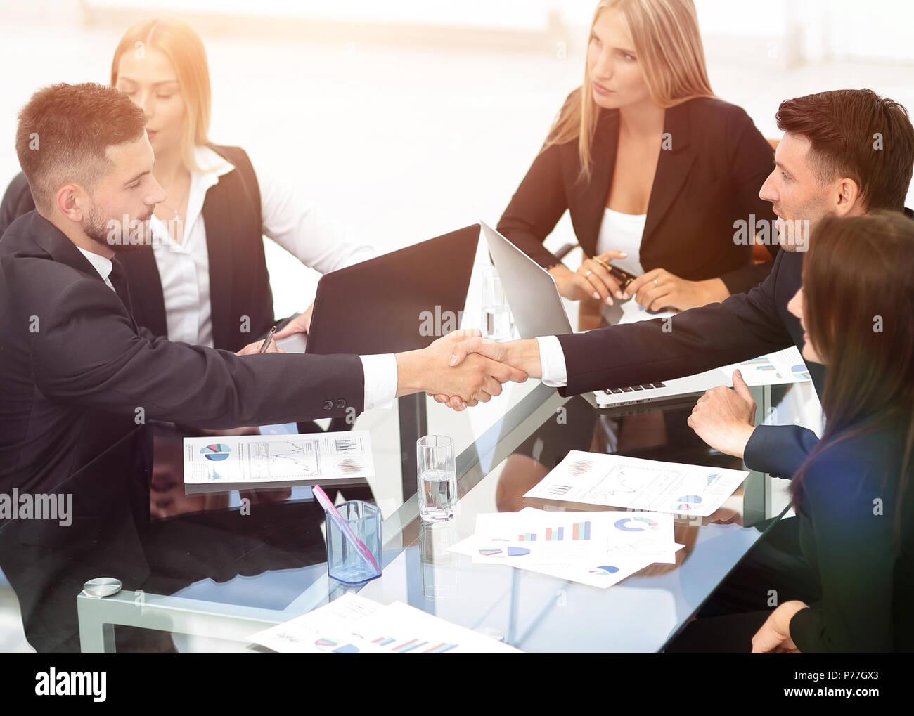 handshake of business partners sitting at your Desk Stock Photo - Alamy