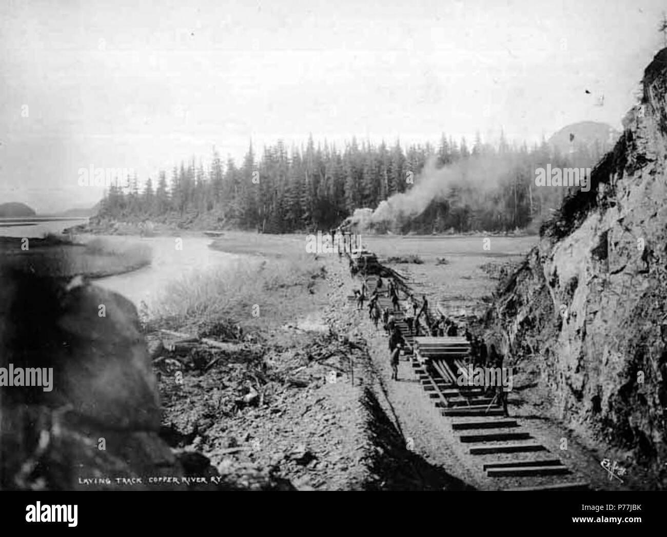 . English: Railroad workers laying track in the vicinity of Mile 22 ...