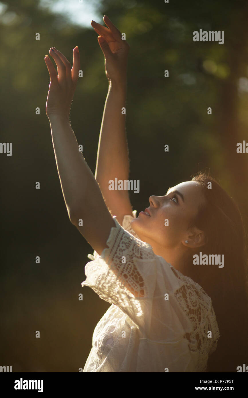 Woman lifting her hands up to sunlight Stock Photo - Alamy