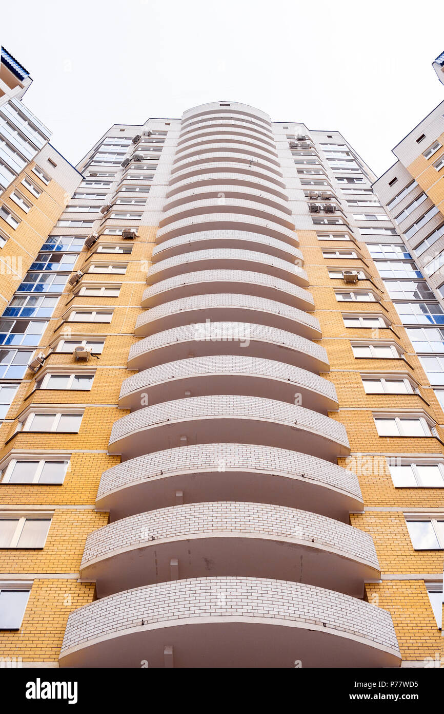 Close-up figured convex balconies of multi-storey yellow modern brick ...