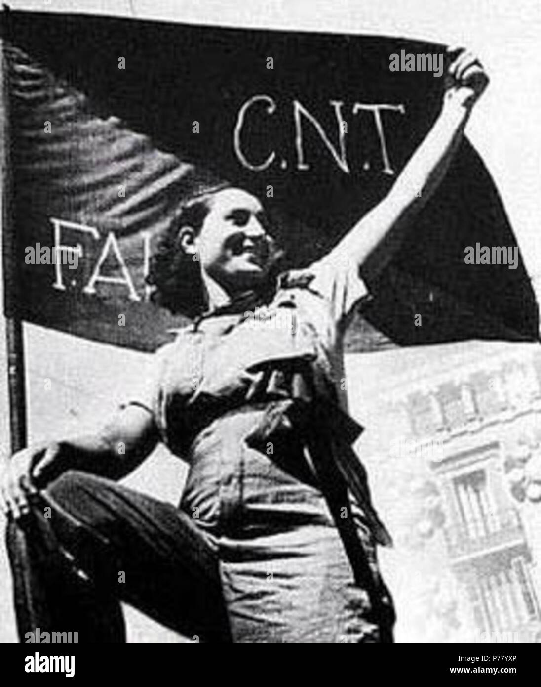 A woman with raised fist in front of a CNT-FAI flag. Unknown date; mid ...