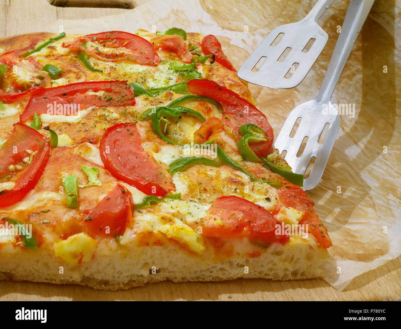 Fresh baked piece of pizza and tongs Stock Photo - Alamy