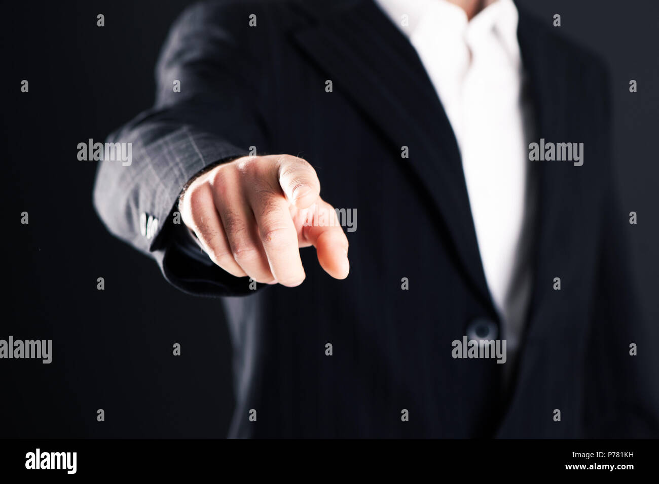 Business man pointing finger on dark background Stock Photo - Alamy