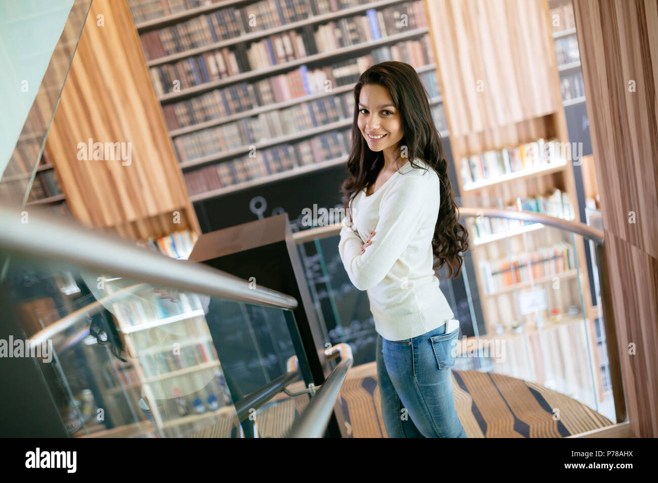 Beautiful brunette in library Stock Photo - Alamy