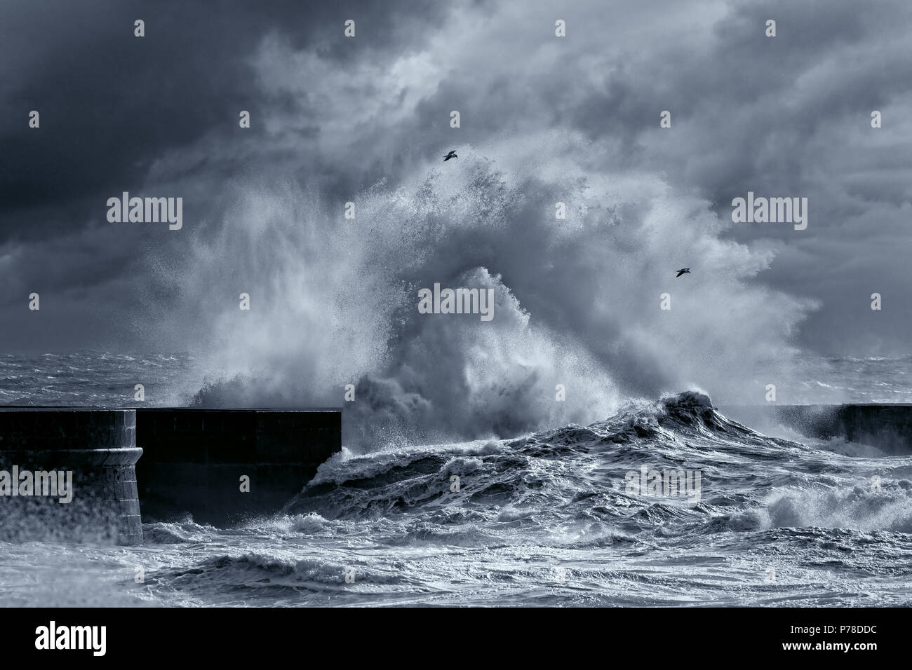 Big stormy waves against pier from the north of Portugal. Enhanced sky ...